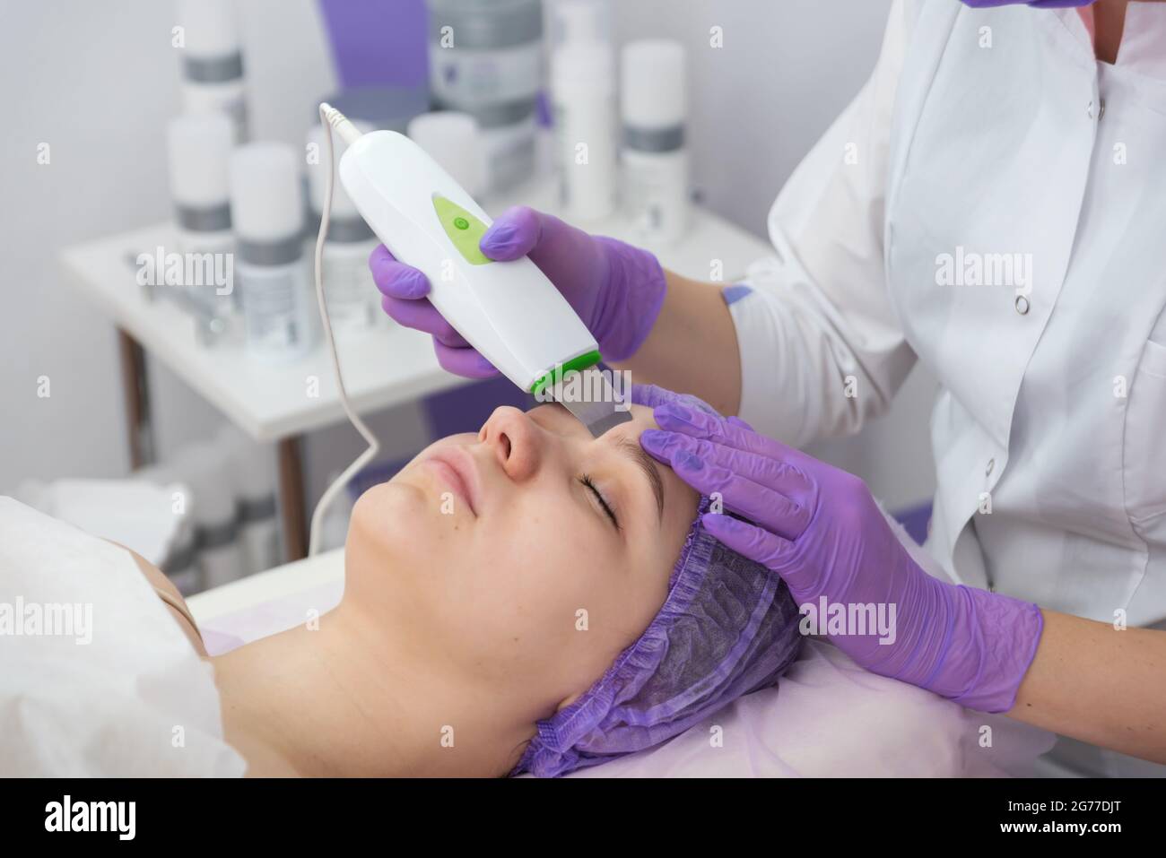 Beauty salon. The cosmetologist makes a water peeling procedure for the ...
