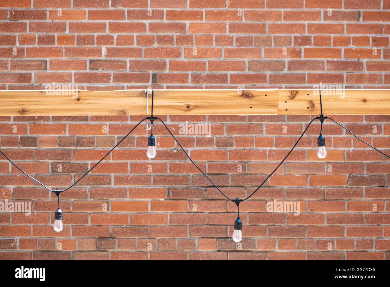 Electric Bulbs with wire on Red Brick Wall Background Stock Photo - Alamy