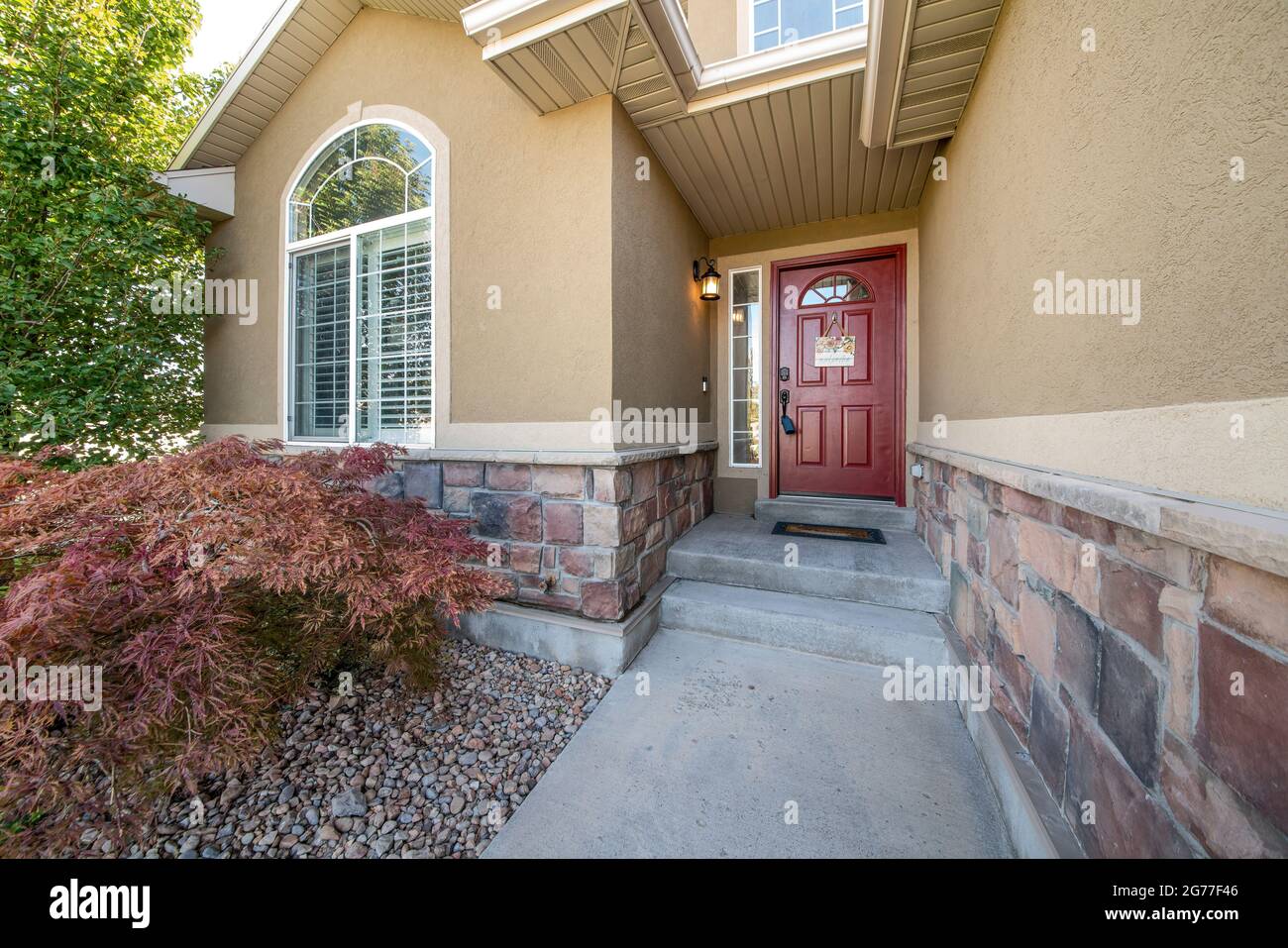 Front exterior of a house with half stone wall siding Stock Photo - Alamy