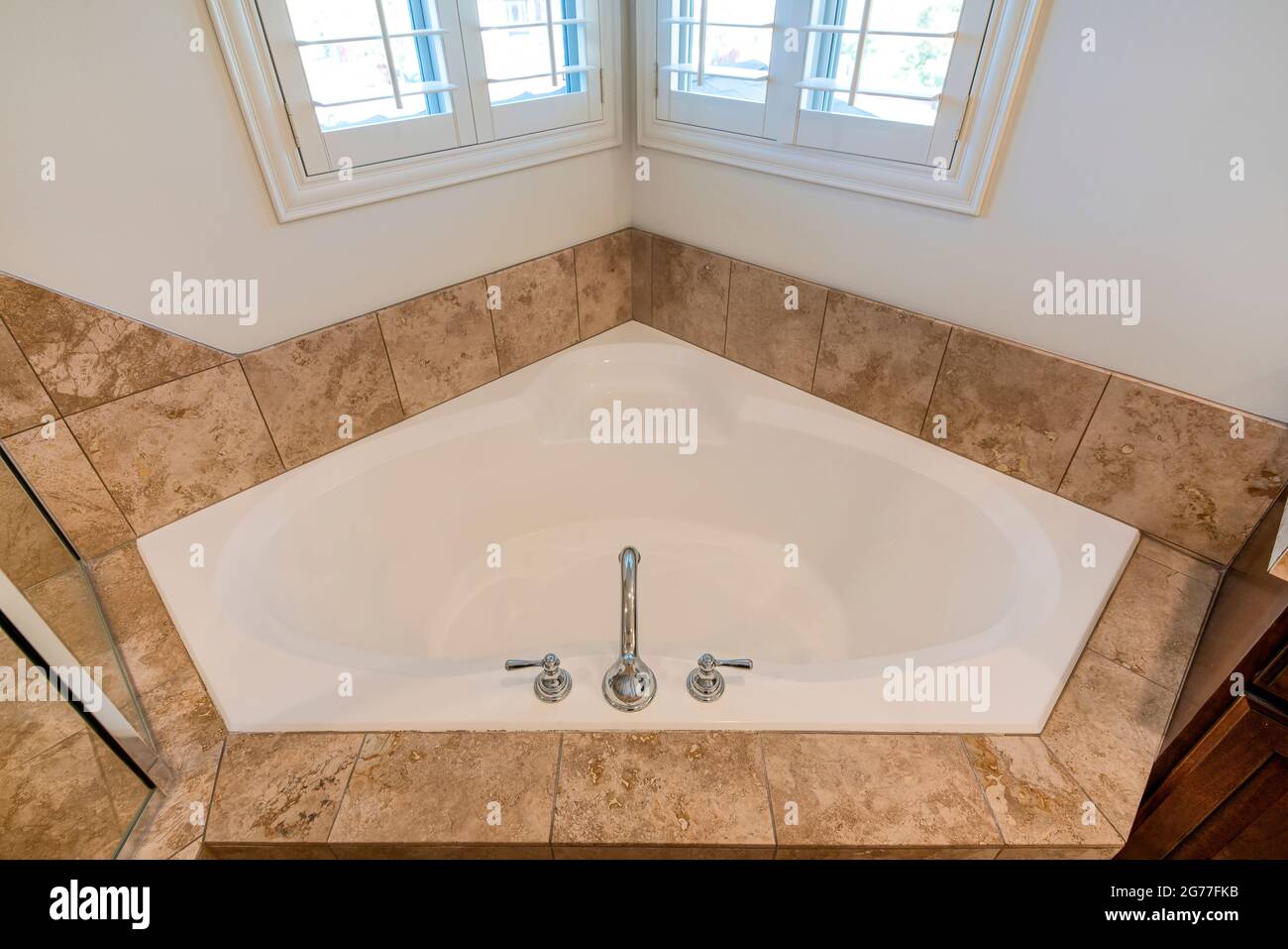 Close up top view of a corner bathtub in a bathroom with ceramic tile ...