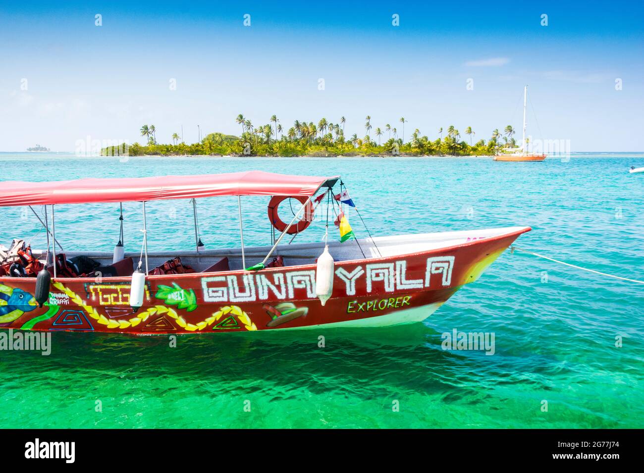 A small boat floating near the coast of a Caribbean island. Clear water ...