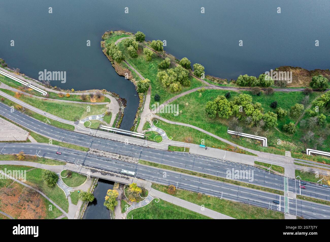 aerial landscape with lake shore, small traffic bridge over water canal ...