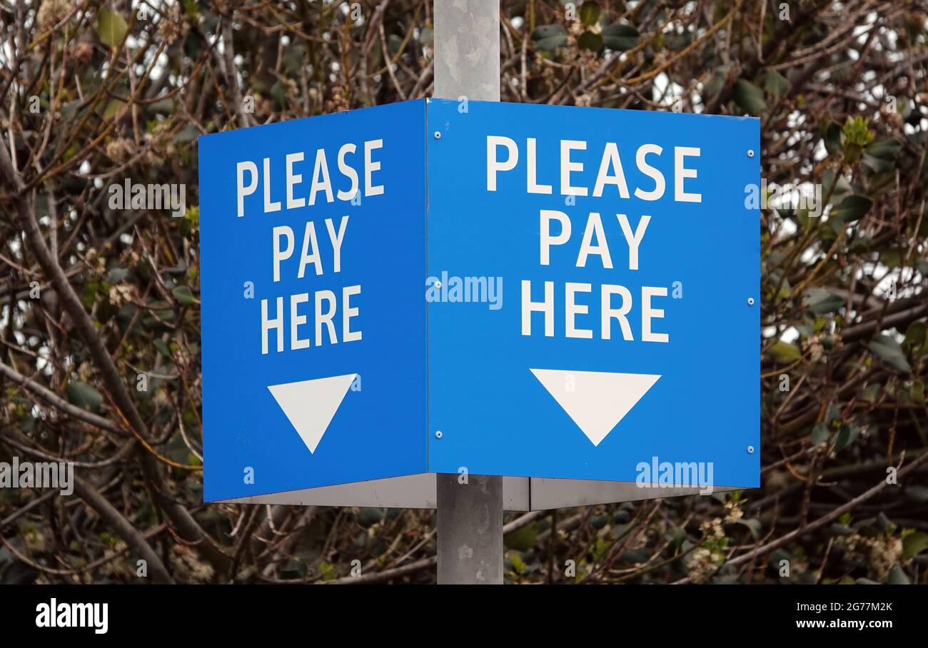 Closeup shot of a blue sign showing the direction of the payment place ...
