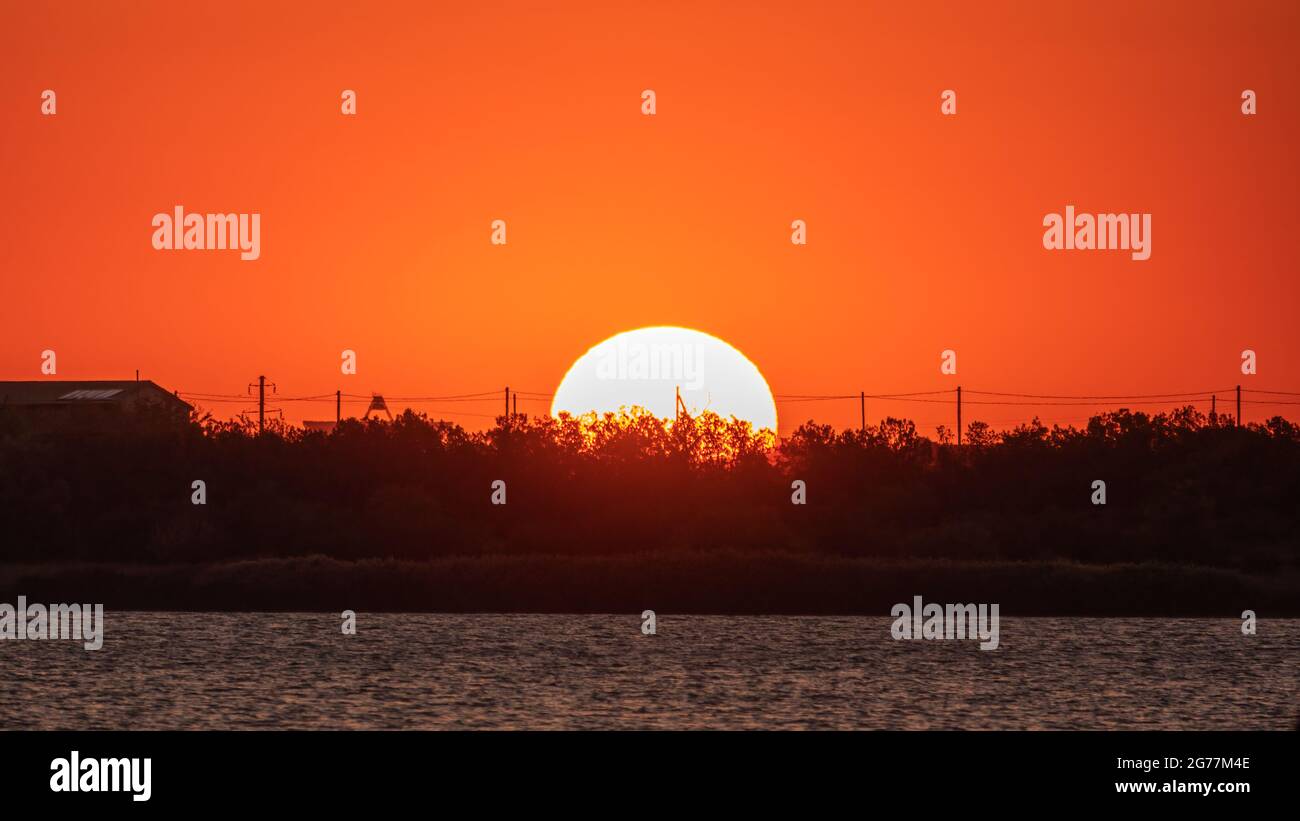 The sun goes down over a lake. Dramatic Sunset Sky Stock Photo - Alamy