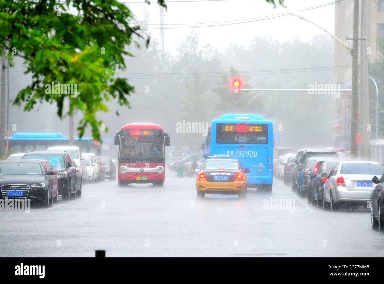 BEIJING, CHINA - JULY 12, 2021 - Pedestrians walk during a rainstorm in ...