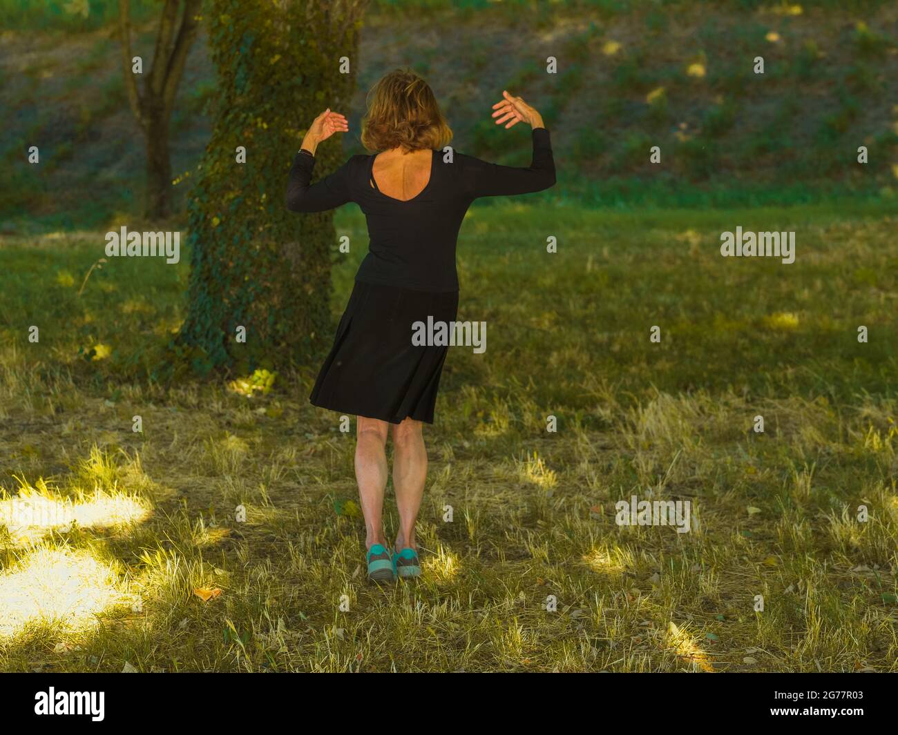 Back view of a senior woman wearing a black dress and dancing Stock ...