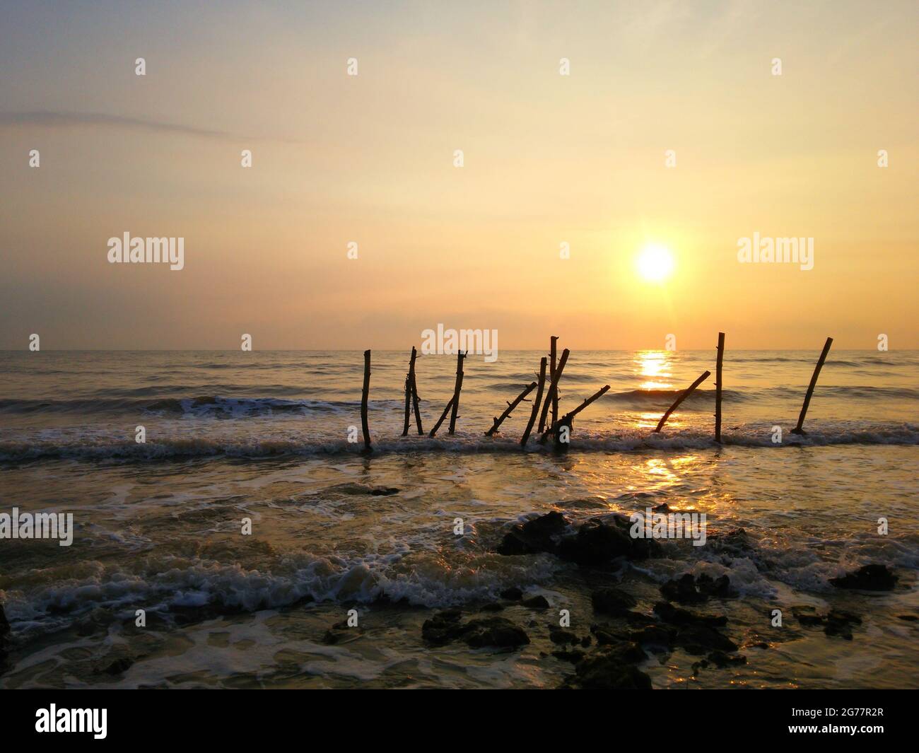 Wooden sticks on the beach during a scenic sunset Stock Photo - Alamy