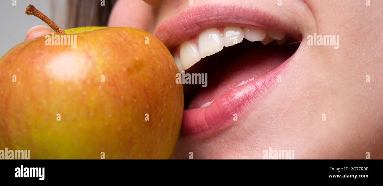 Beautiful young woman eating red apple. Biting an apple. Mouth close up ...