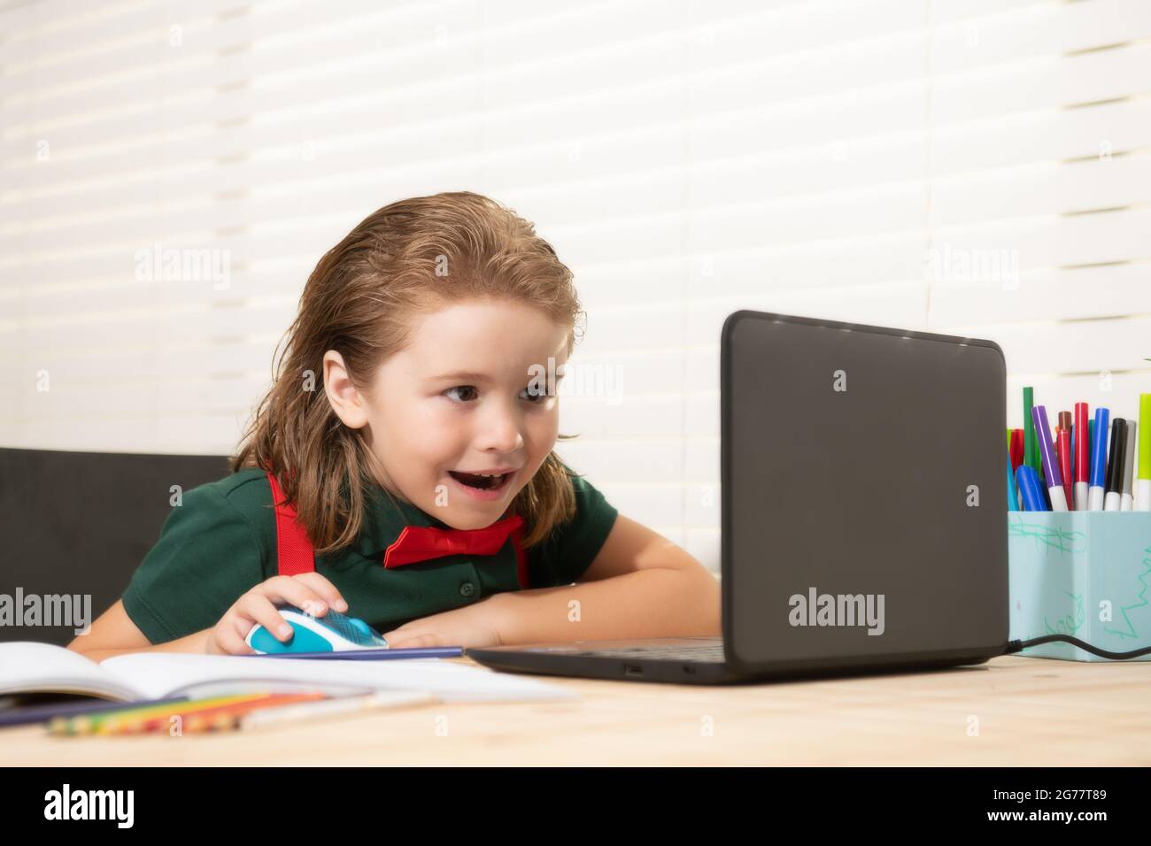 School boy with a happy smiling face studying and using computer laptop ...