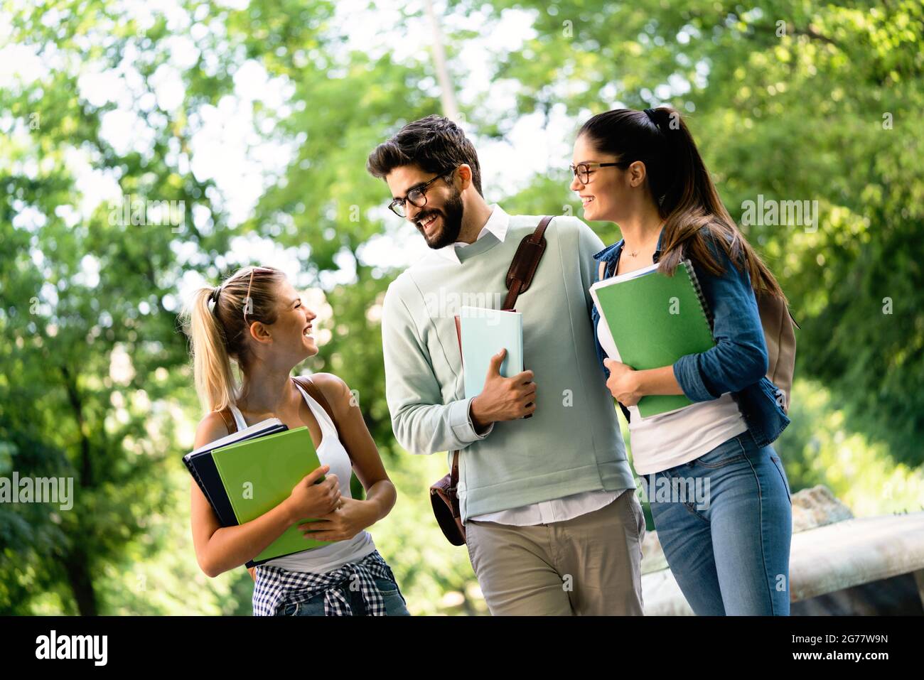 Happy young university students friends studying with books at ...