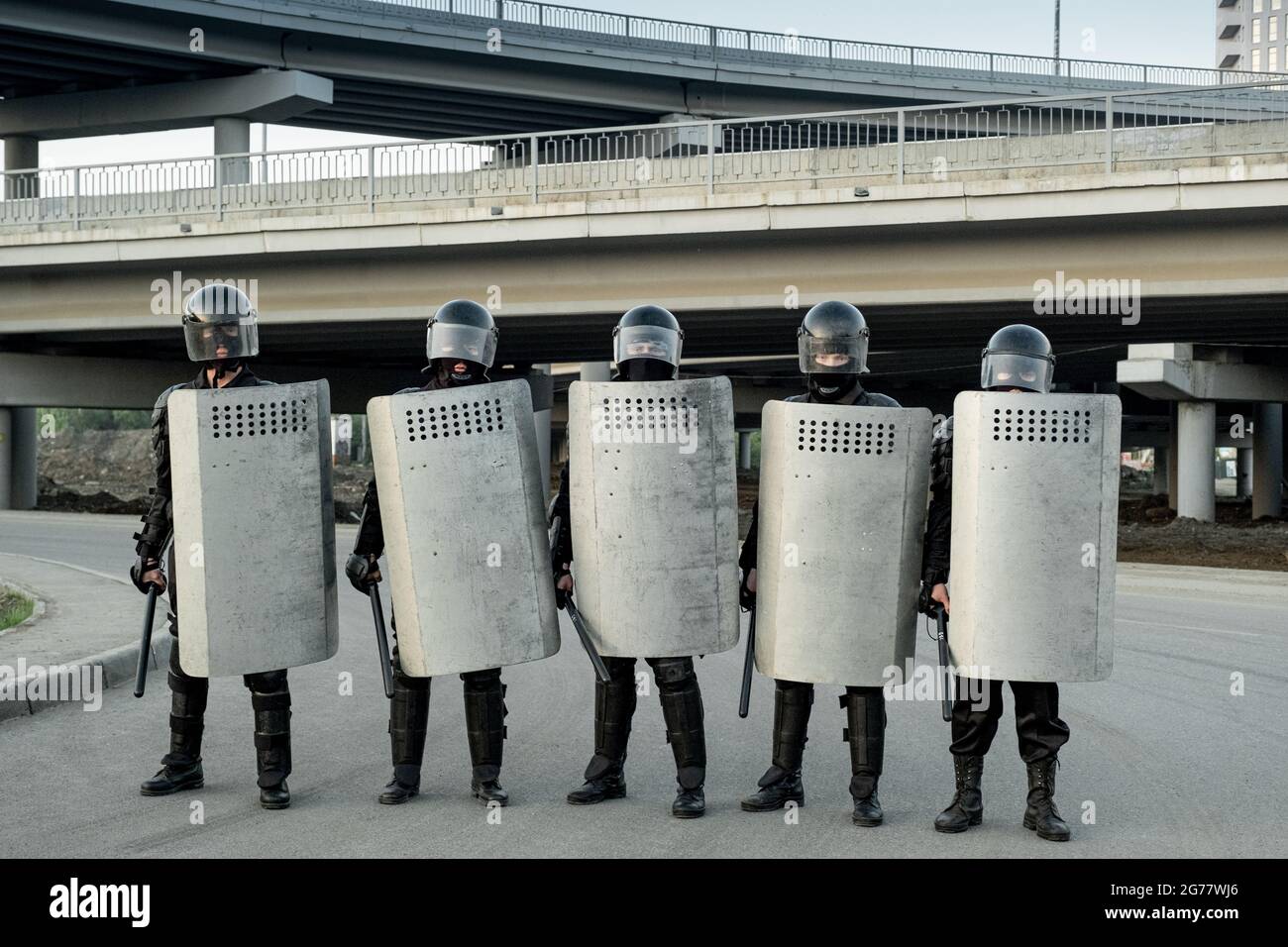 Group of police guards in helmets holding side handle batons and riot ...