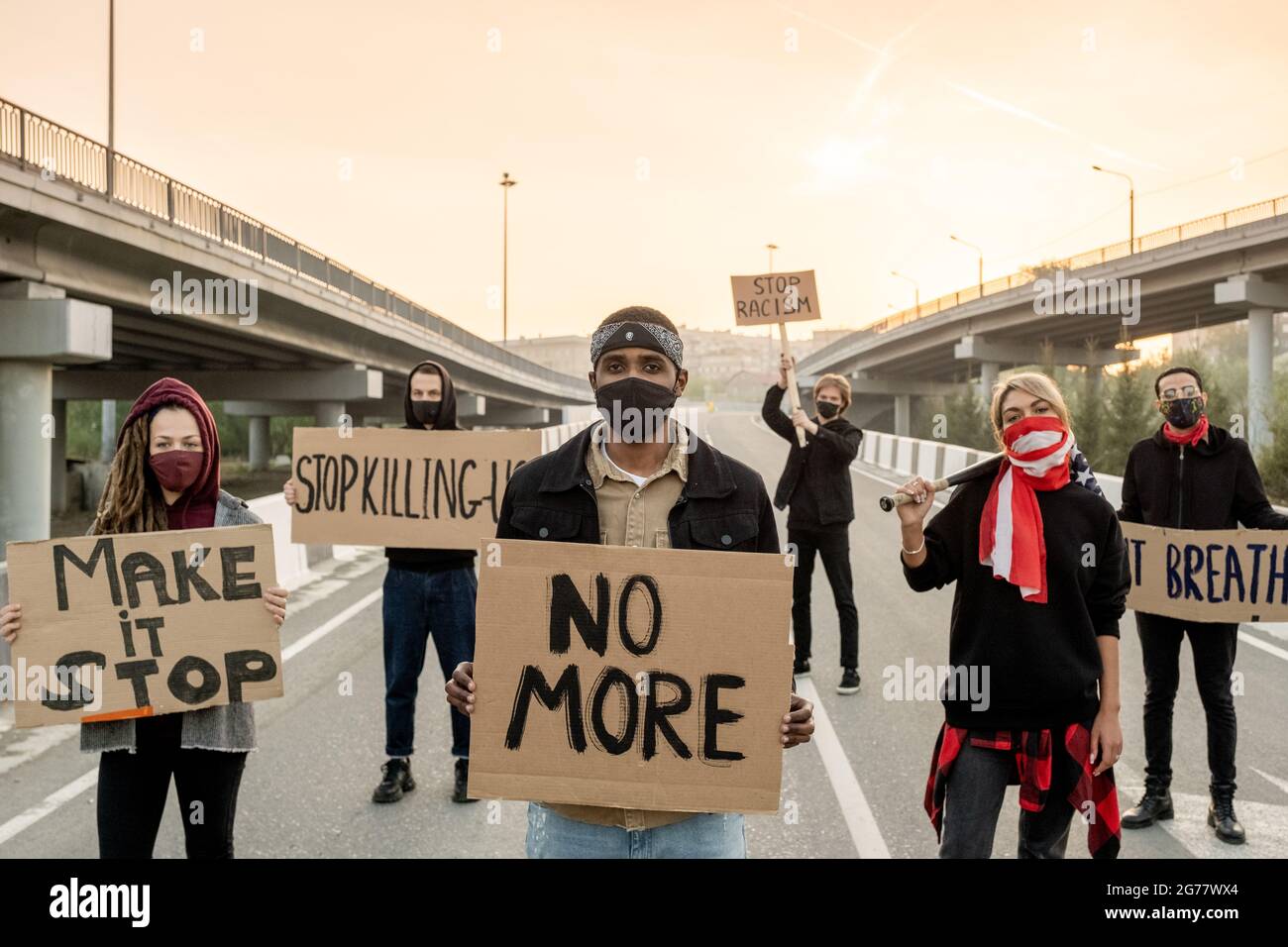 Portrait of serious displeased young people in masks standing with ...