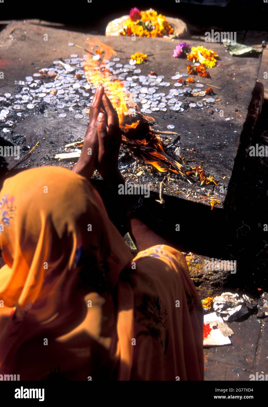 A Hindu woman offering fire puja to the God Agni at a temple in India ...