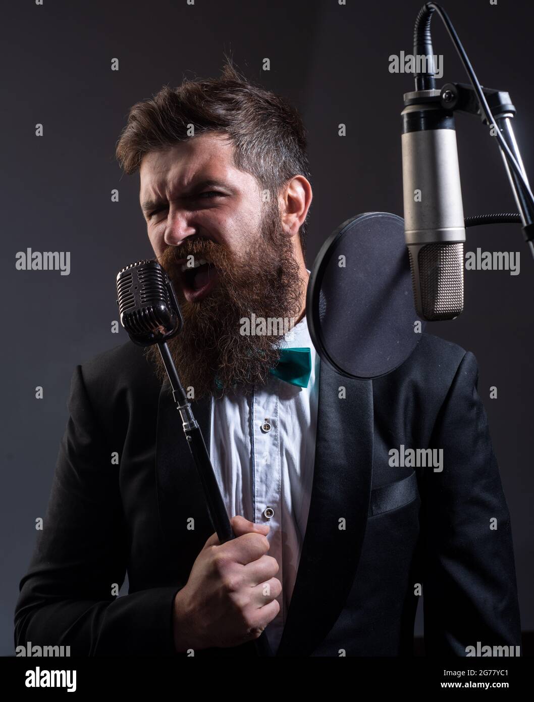 Portrait of bearded man with microphone singing song. Musician in music ...