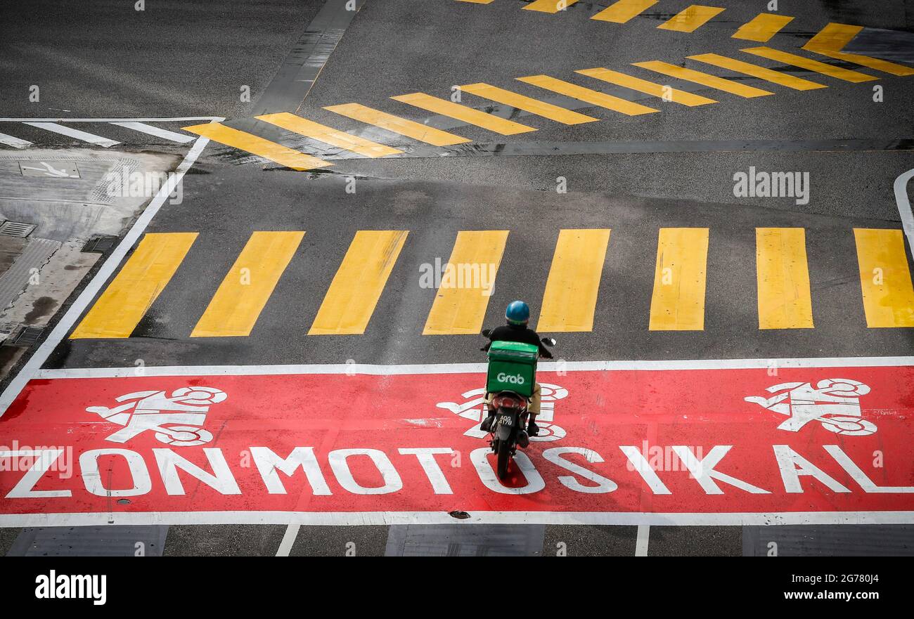 A food delivery rider seen riding along an empty street in downtown ...