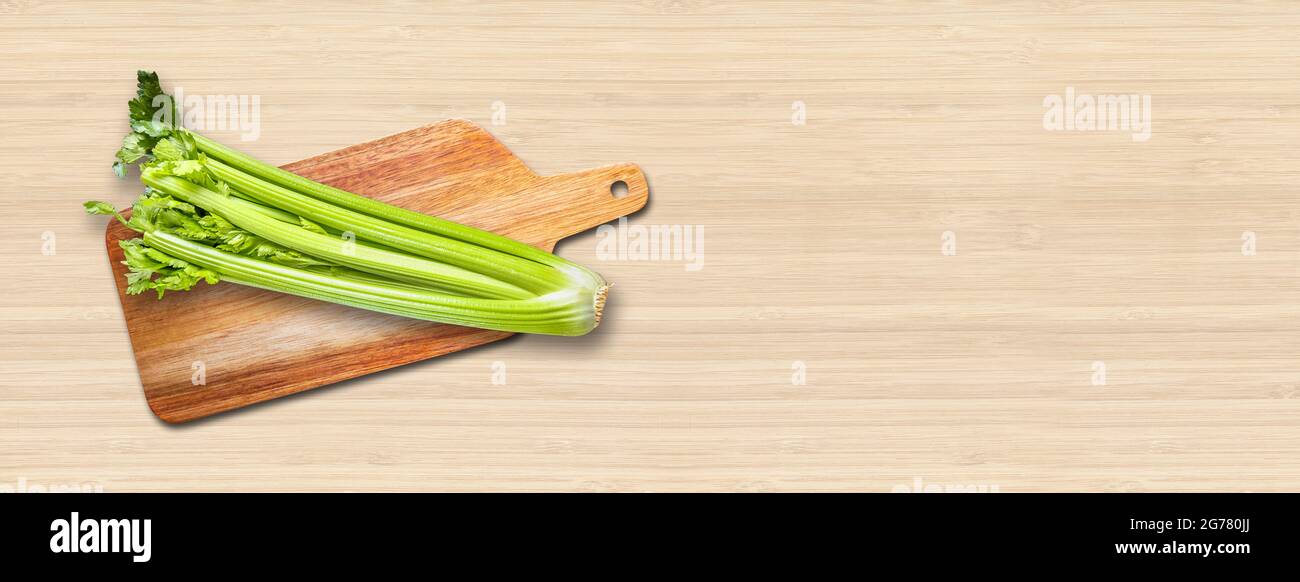 Celery branch bunch on a wooden cutting board. Isolated on wood banner ...