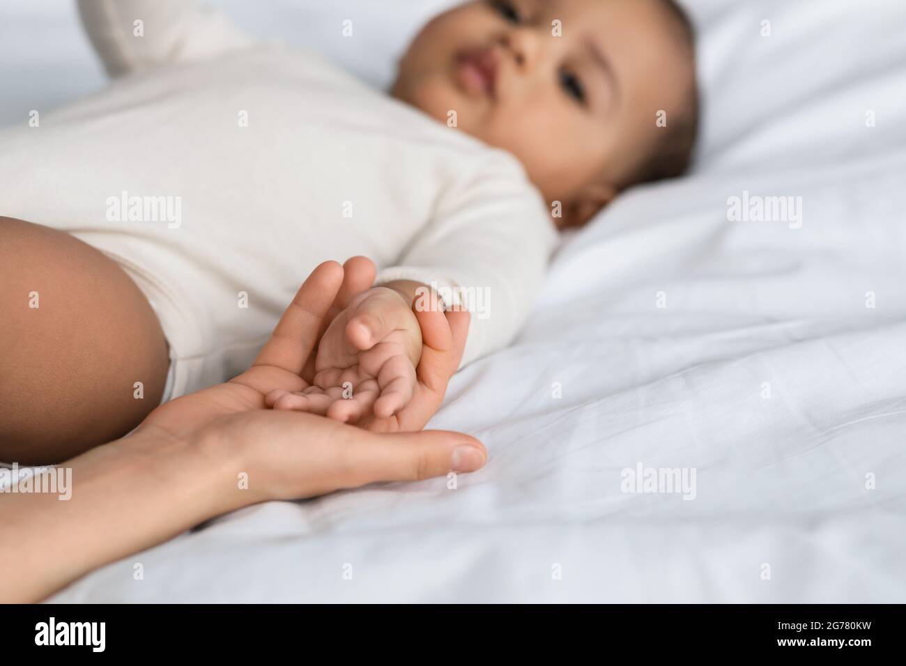 Cute little African American baby holding hands with mom Stock Photo ...