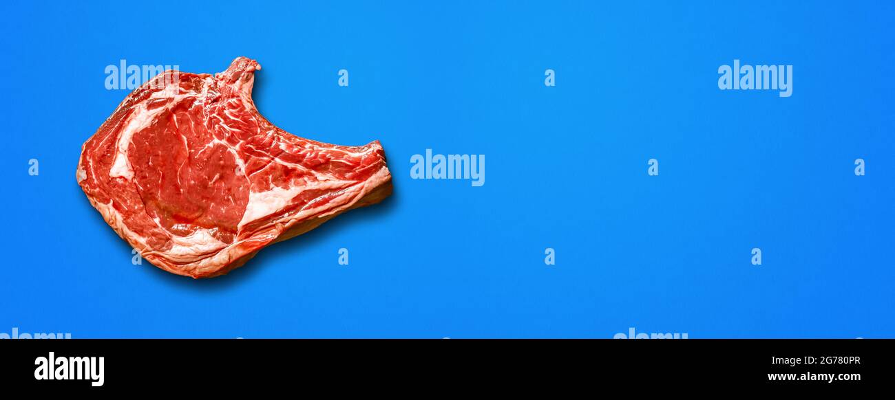 Raw beef prime rib isolated on blue background. Top view. Horizontal ...