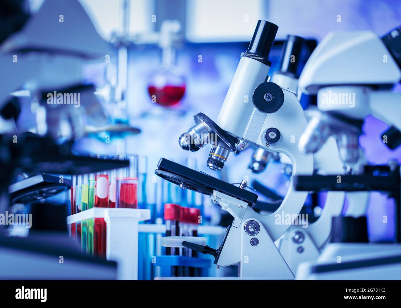 Microscope in and laboratory and test tube equipment in lab blue lights ...