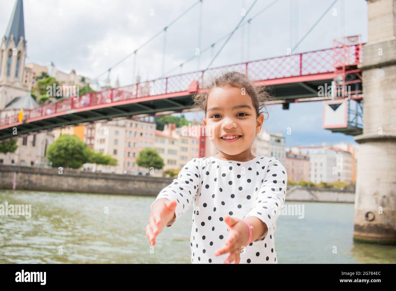Happy girl playing in the city of Lyon with a footbridge and the St ...