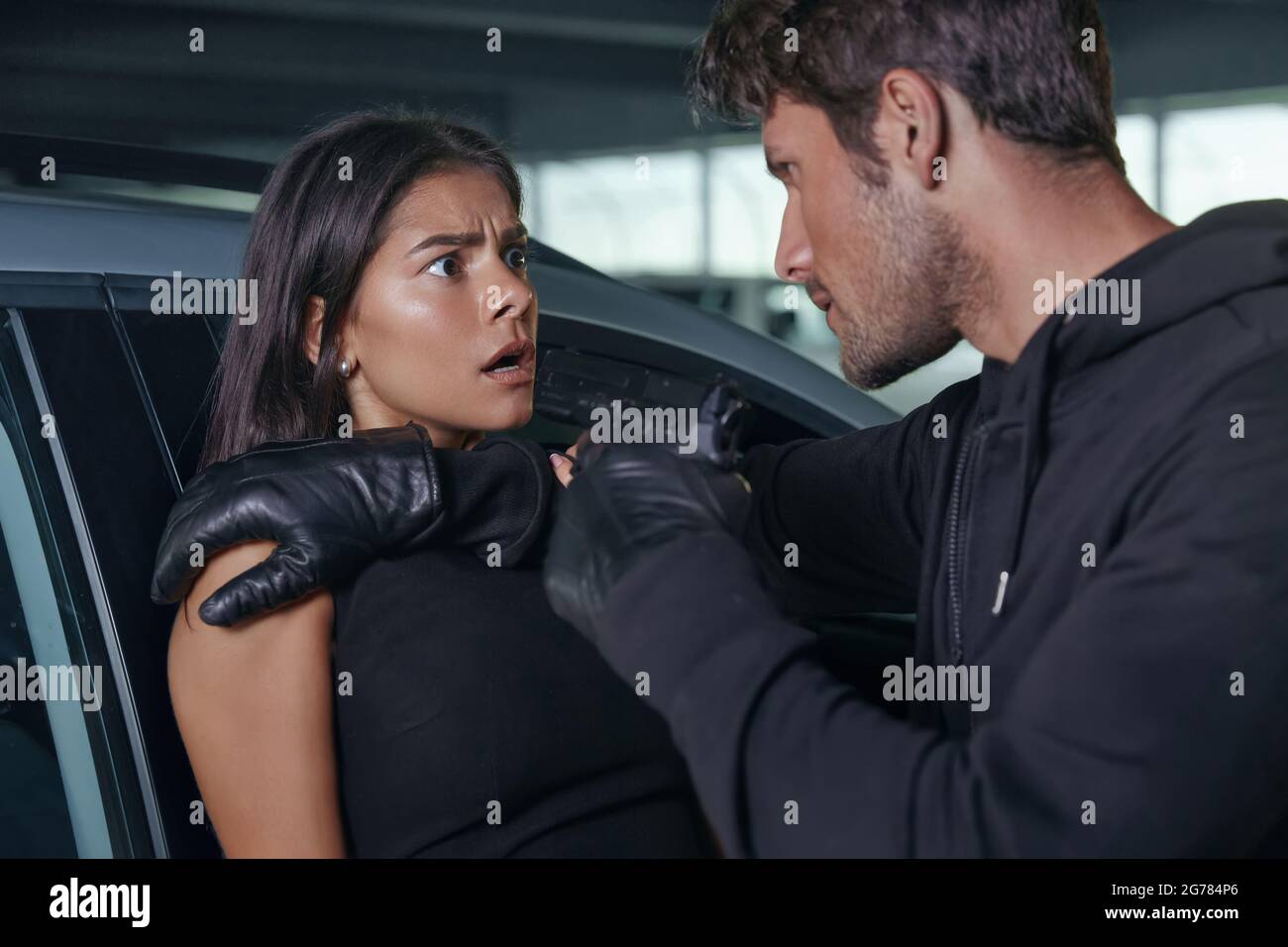 Aggressive robber threatening with pistol to scared girl. European man ...