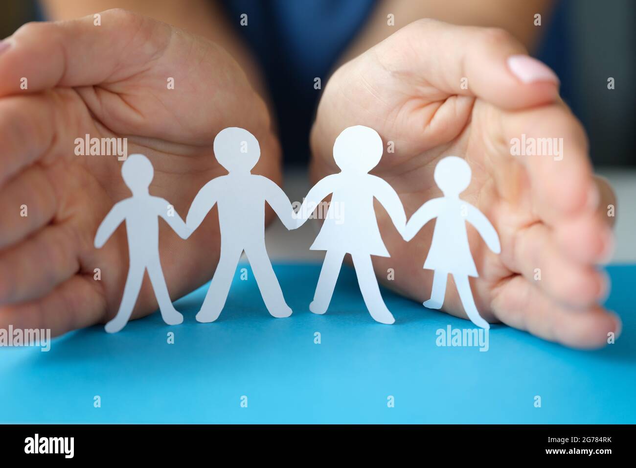 Women hands protect a family with children from paper Stock Photo - Alamy