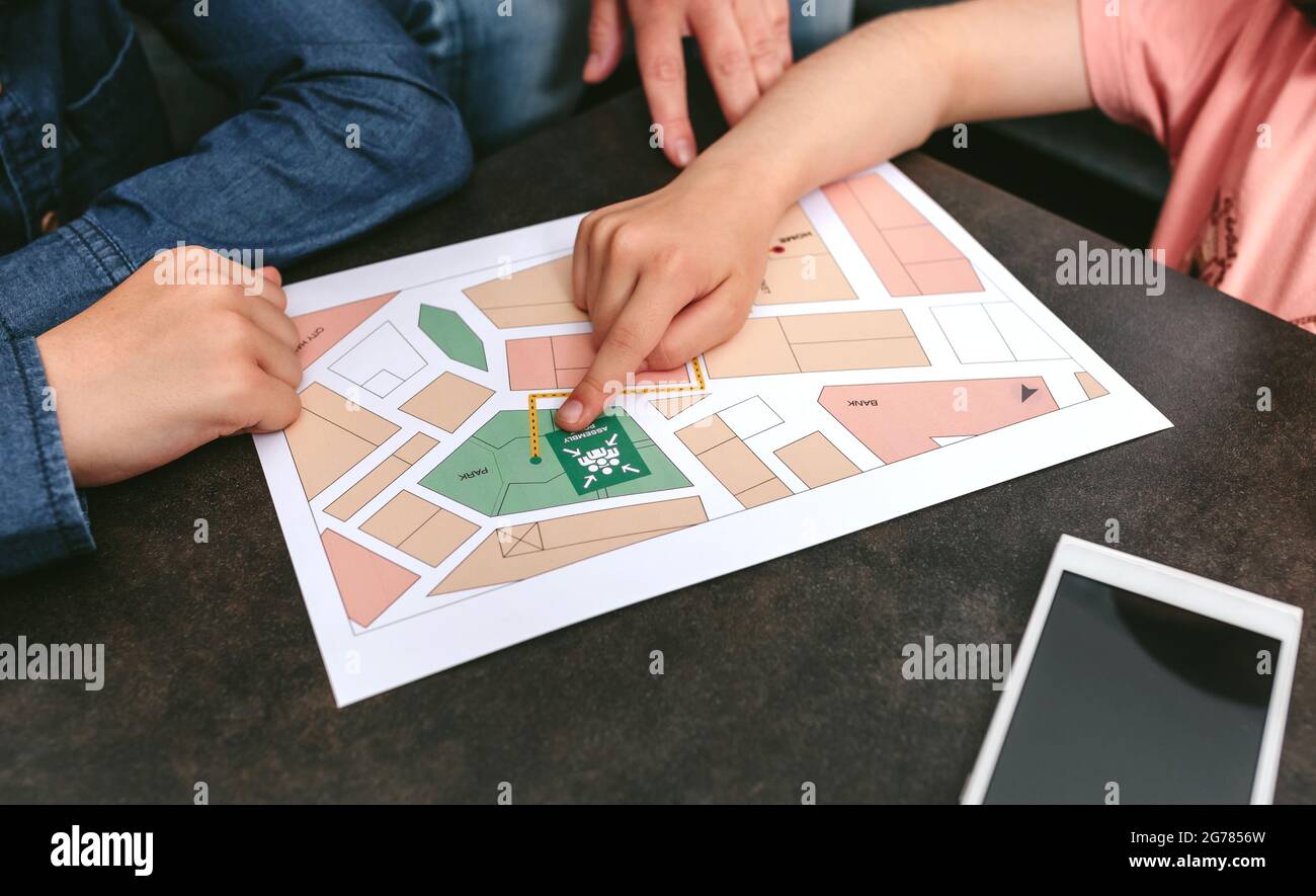 Unrecognizable family looking assembly point map Stock Photo - Alamy