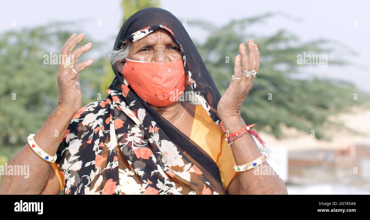 Old Indian woman wearing a traditional sari and face mask- new normal ...