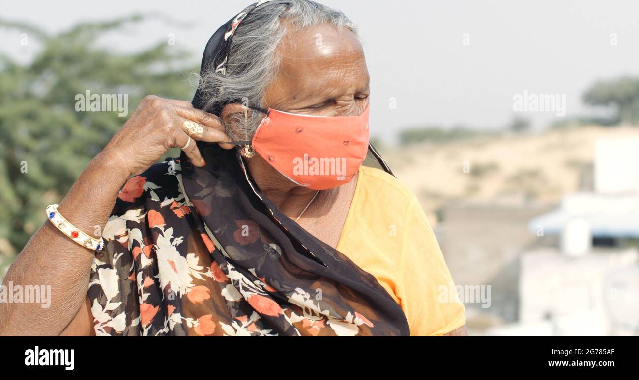 Old Indian woman wearing a traditional sari and face mask- new normal ...