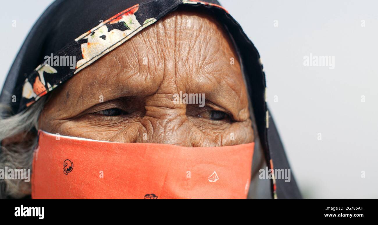 Old Indian woman wearing a traditional sari and face mask- new normal ...