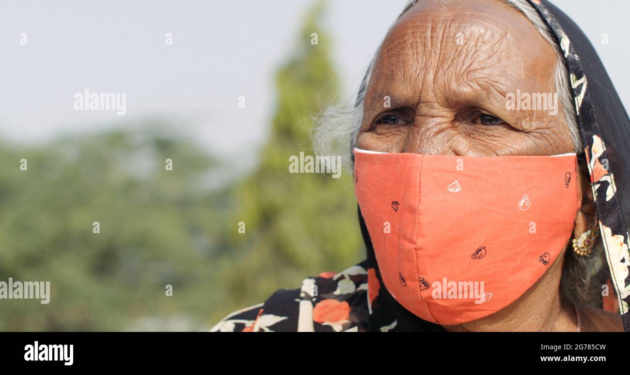 Old Indian woman wearing a traditional sari and face mask- new normal ...