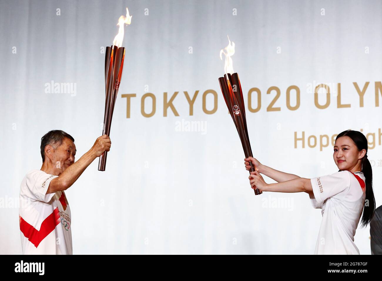 Tokyo, Japan. 12th July, 2021. Torchbearers pose for the cameras during ...