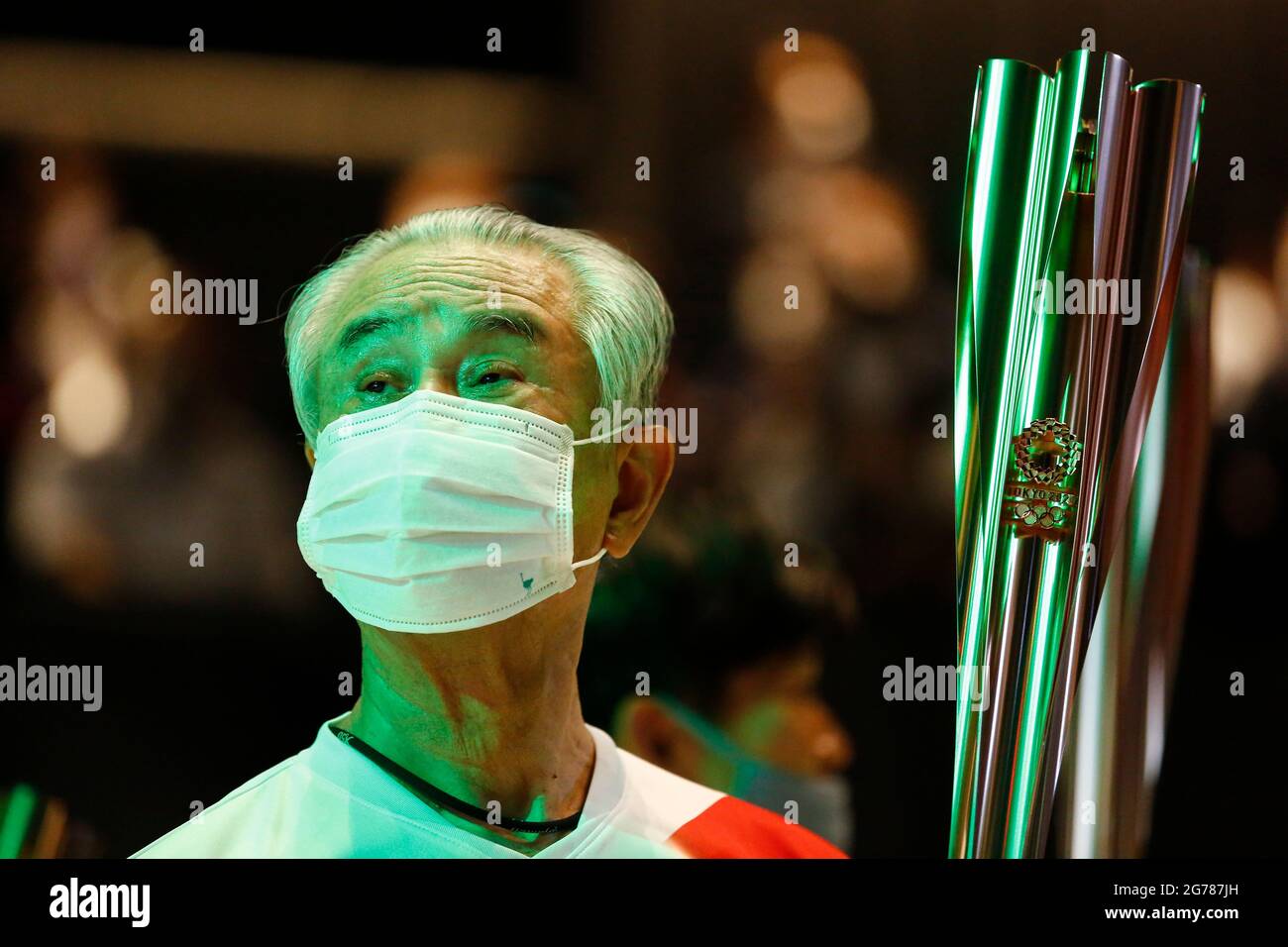 Tokyo, Japan. 12th July, 2021. A torchbearer wearing a face mask ...