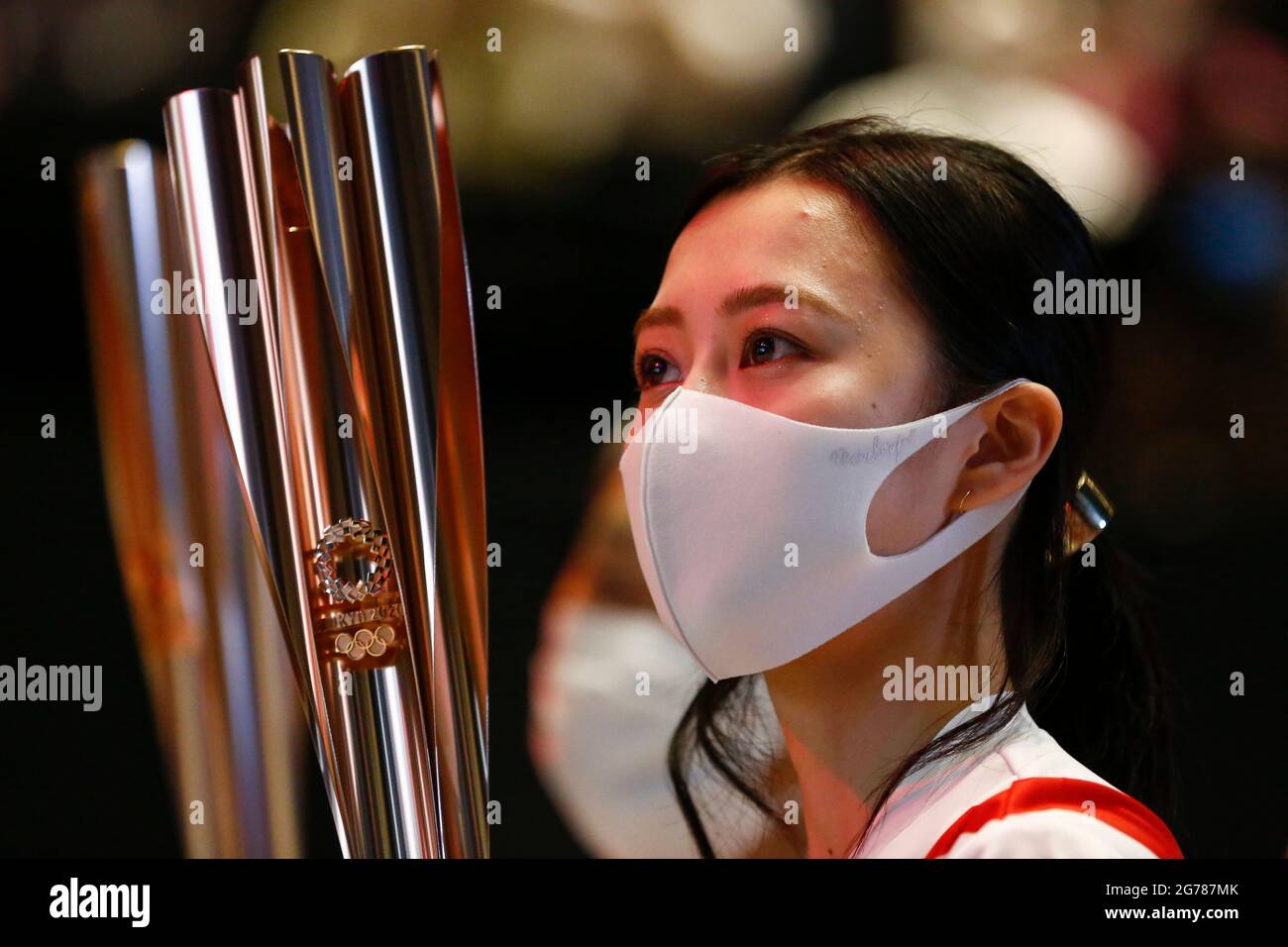 Tokyo, Japan. 12th July, 2021. A torchbearer wearing a face mask ...