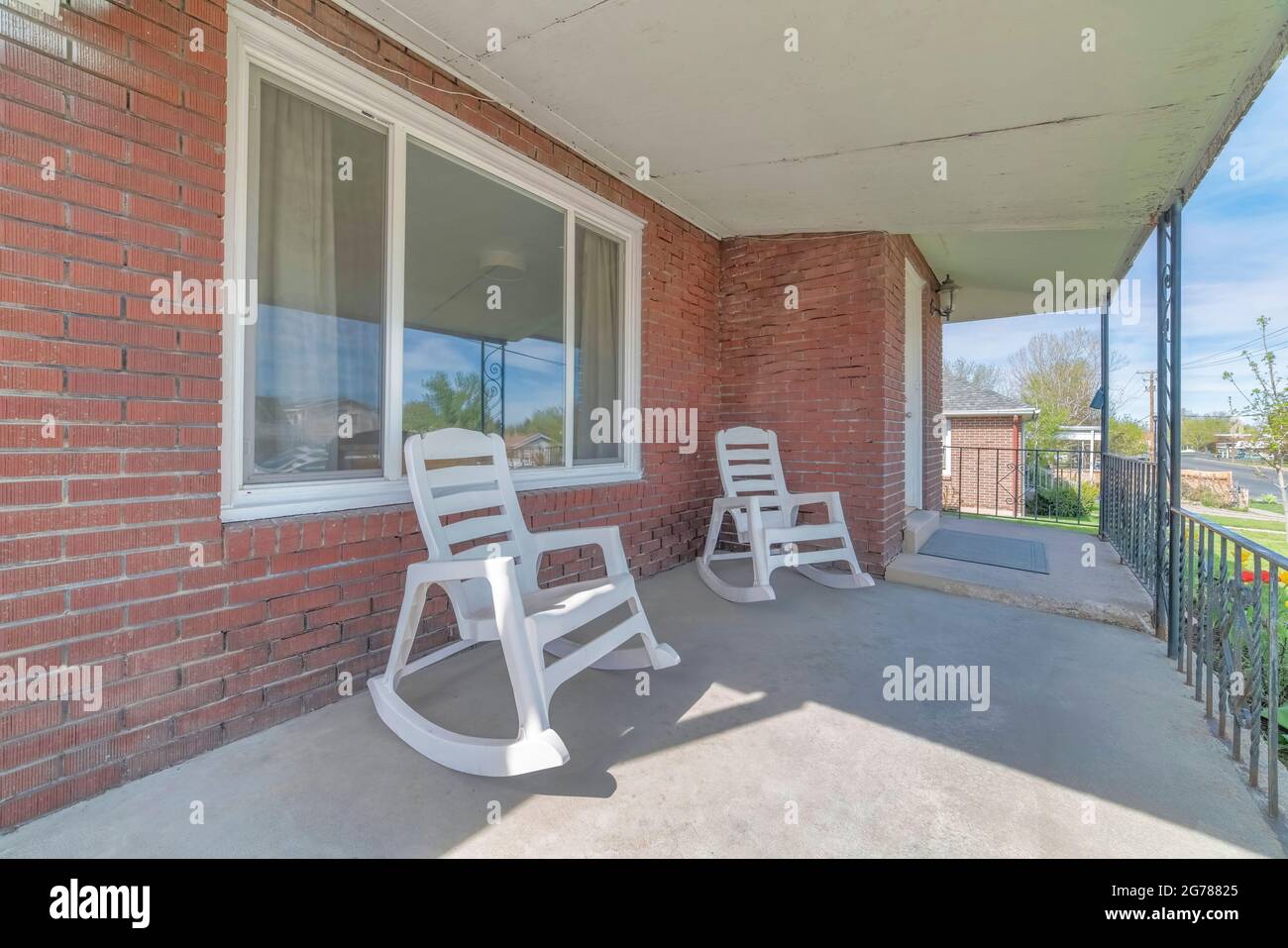 Front porch of house with two rocking chairs against window and red ...