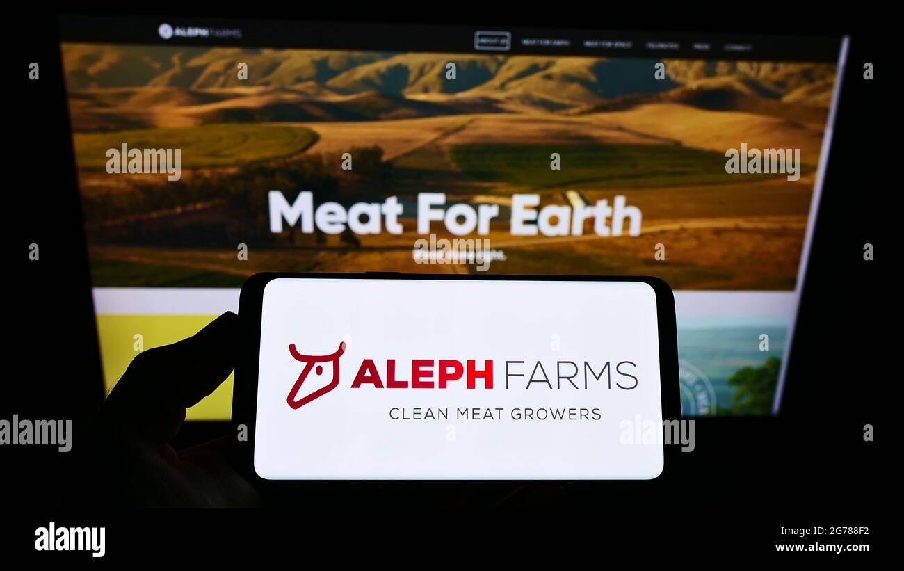 Person holding smartphone with logo of Israeli cultured meat company ...