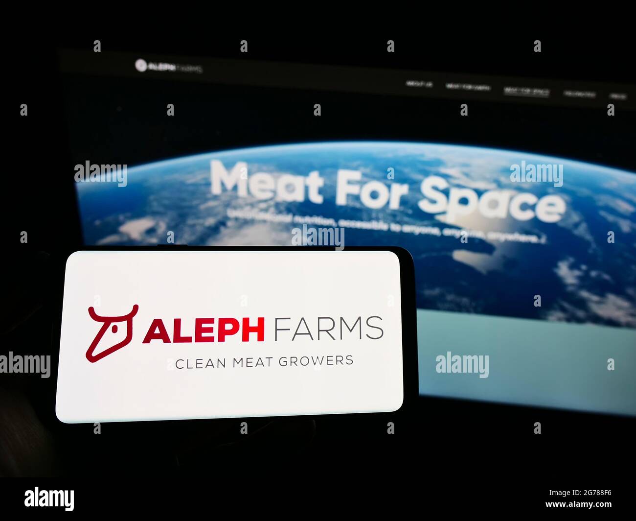 Person holding cellphone with logo of Israeli cultured meat company ...