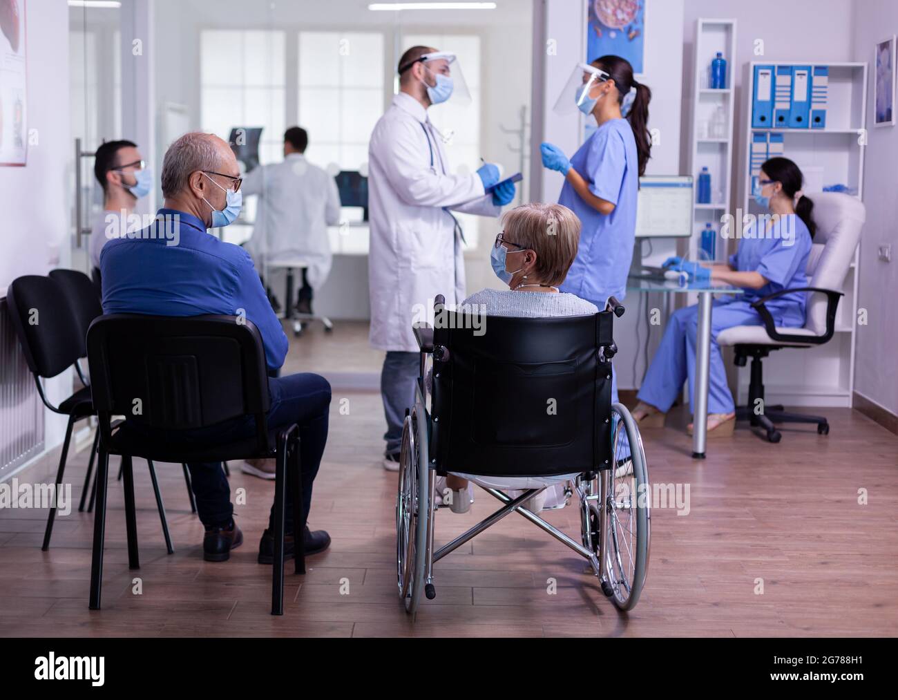 Specialist doctor with visor and protection mask speaking with ...
