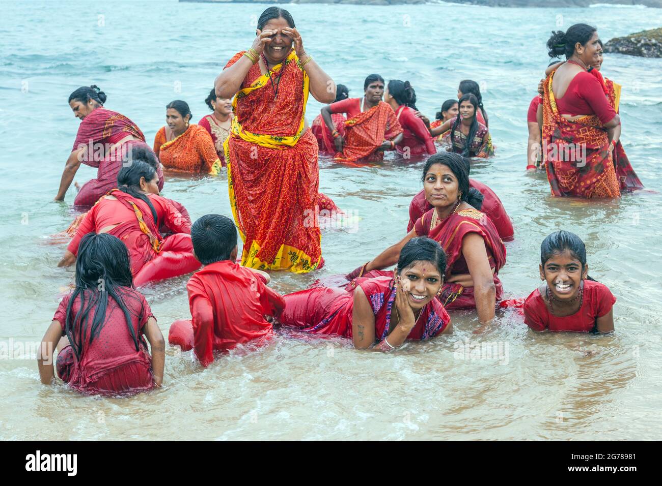 Group of hindu female worshippers wearing red clothing bathing in the ...