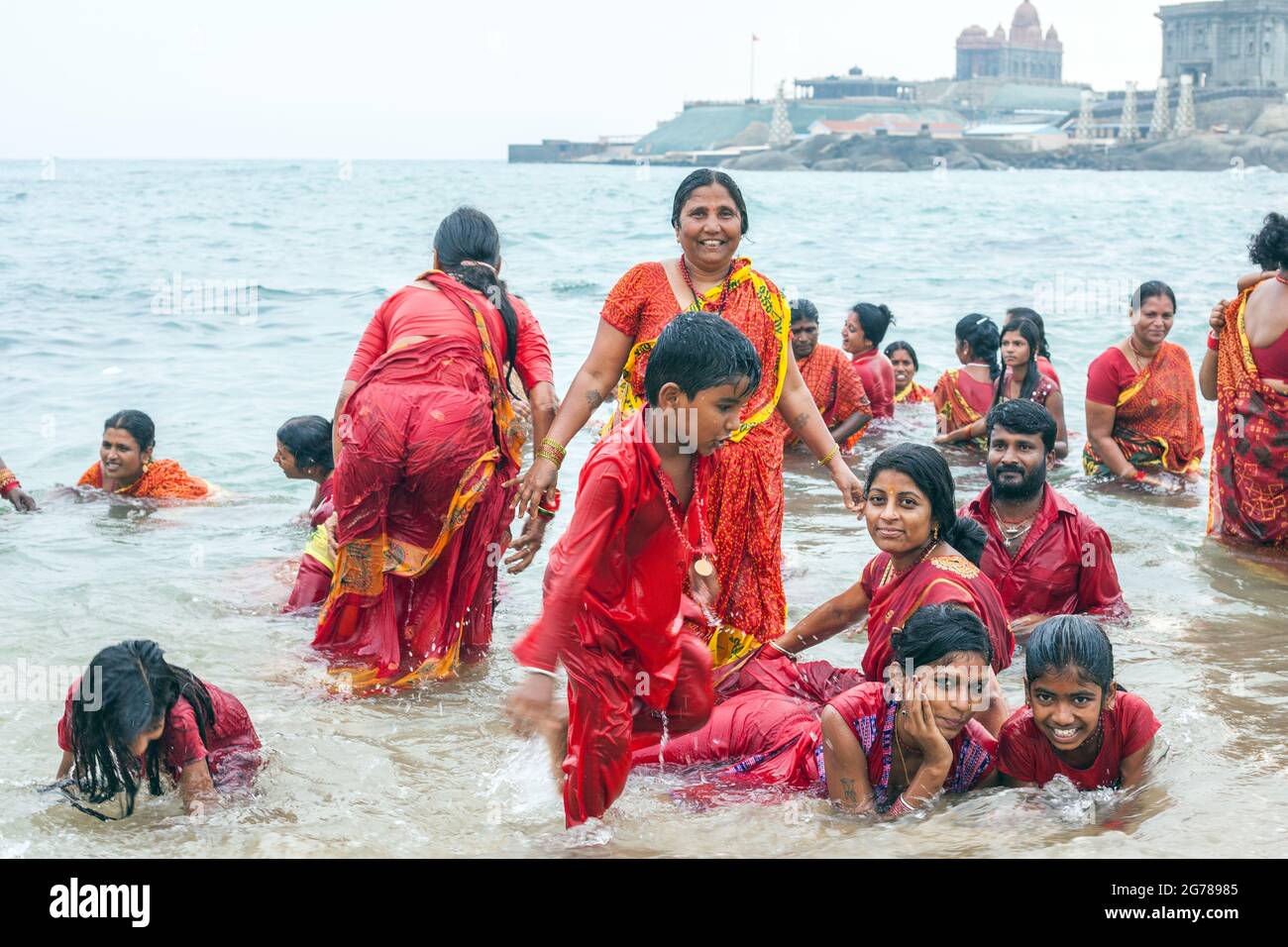 Group of hindu worshippers wearing red clothing bathe in the Laccadive ...