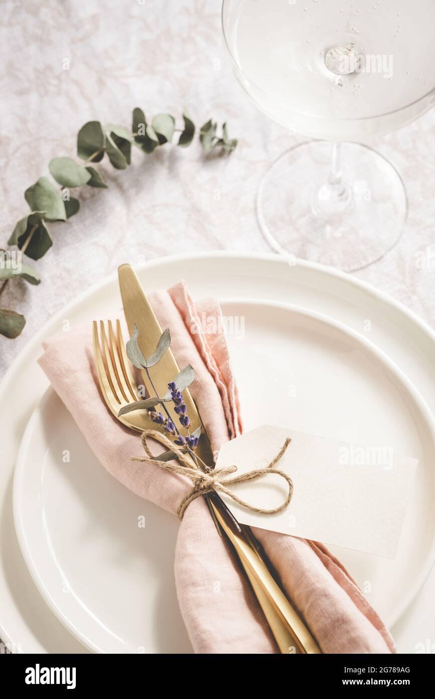 Table setting details with lavender and eucaliptus on white plates ...
