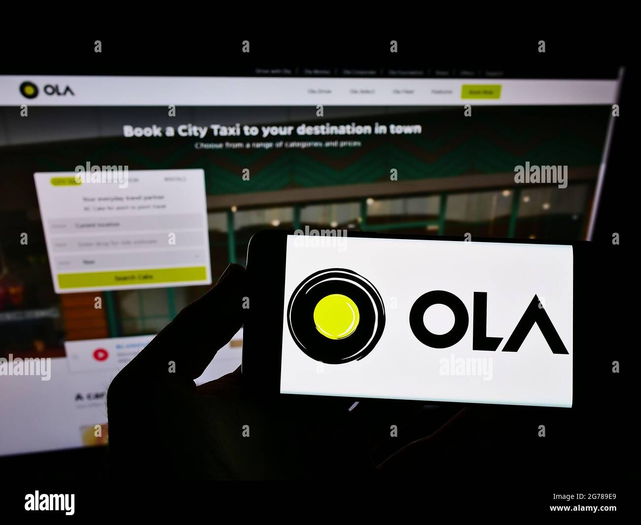Person holding smartphone with logo of Indian ridesharing company Ola ...