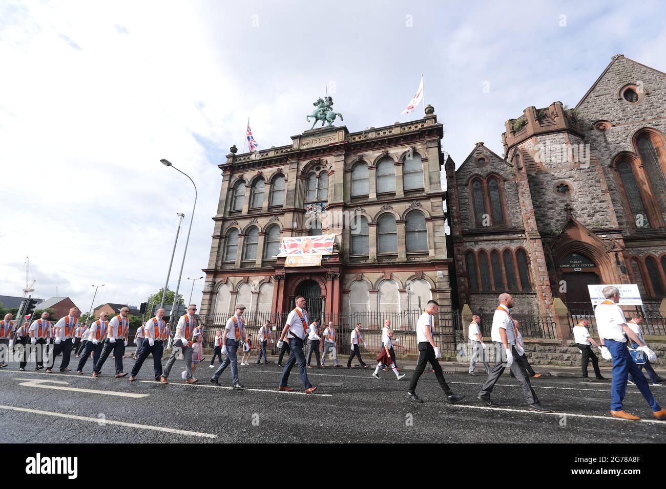 Orangemen march past Clifton Street Orange Hall in Belfast as part of ...