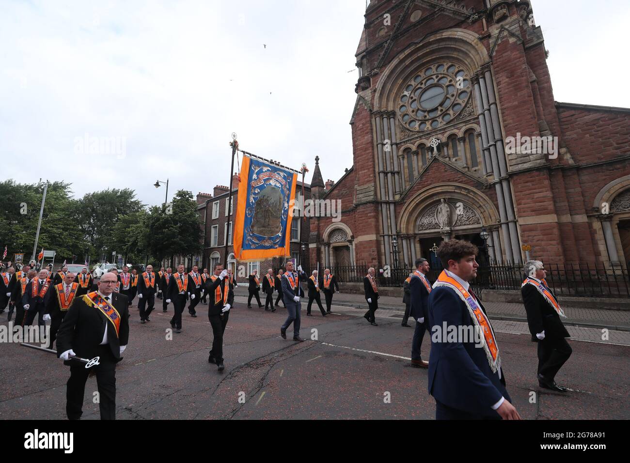 Orangemen march past St Patrick's Catholic church in Belfast as part of ...
