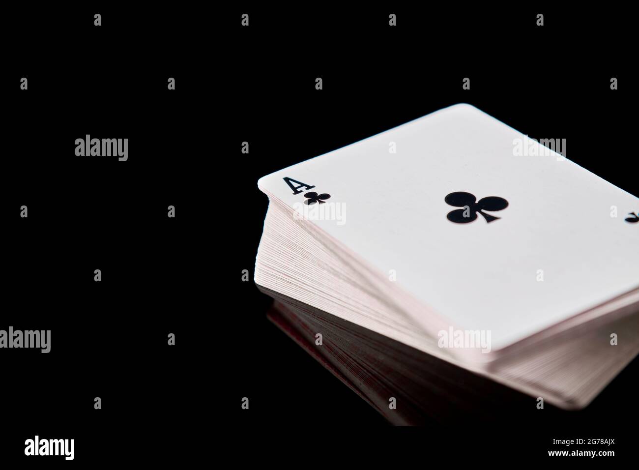 Full deck of playing cards with ace on top on dark reflective ...