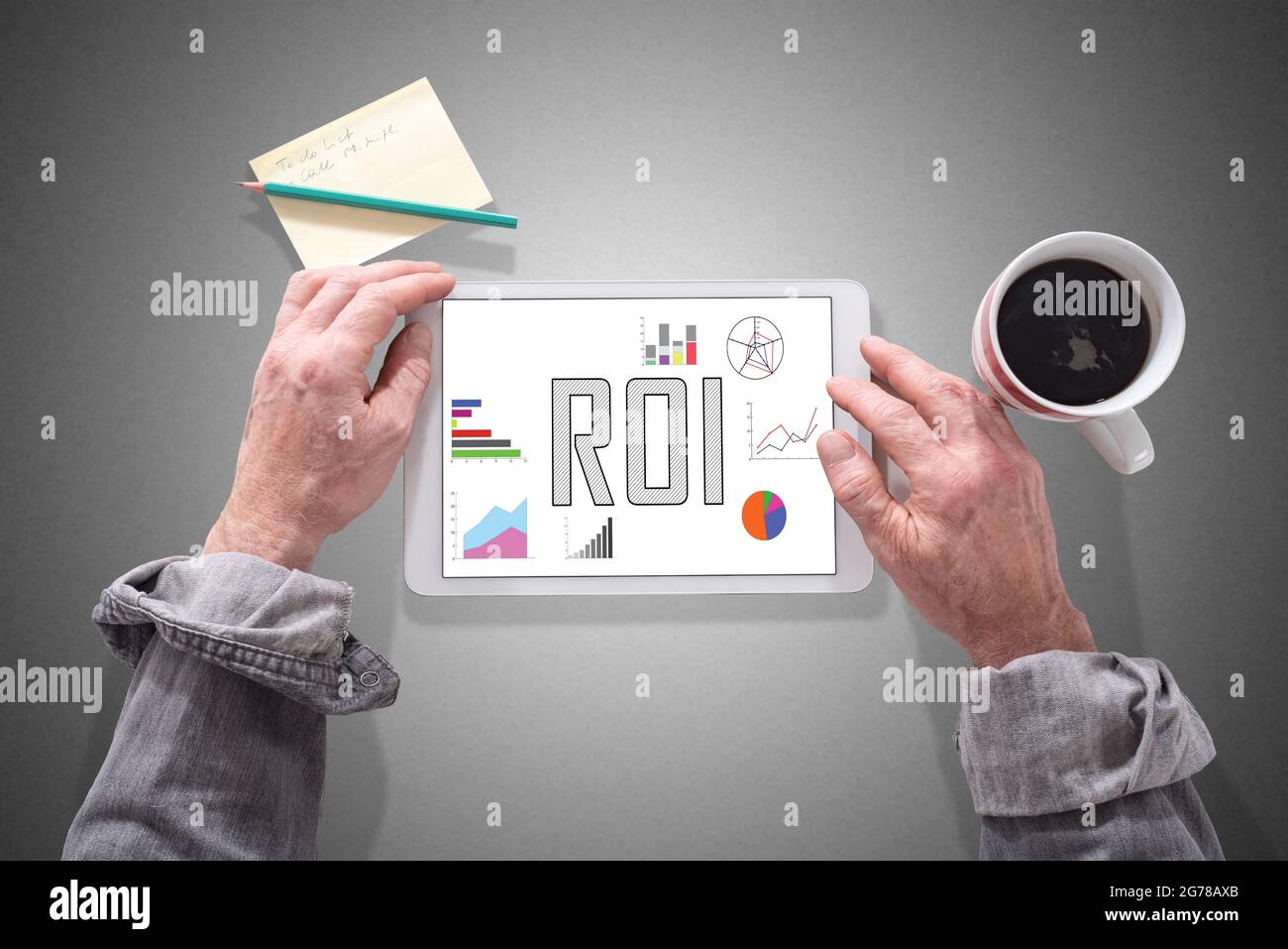 Male hands using a tablet showing roi concept Stock Photo - Alamy