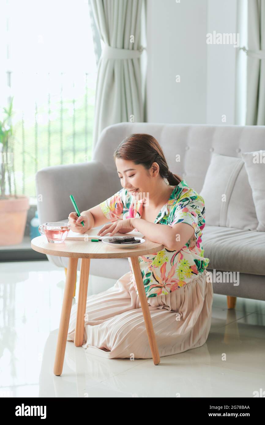 Girl sitting on the floor writing book hi-res stock photography and ...