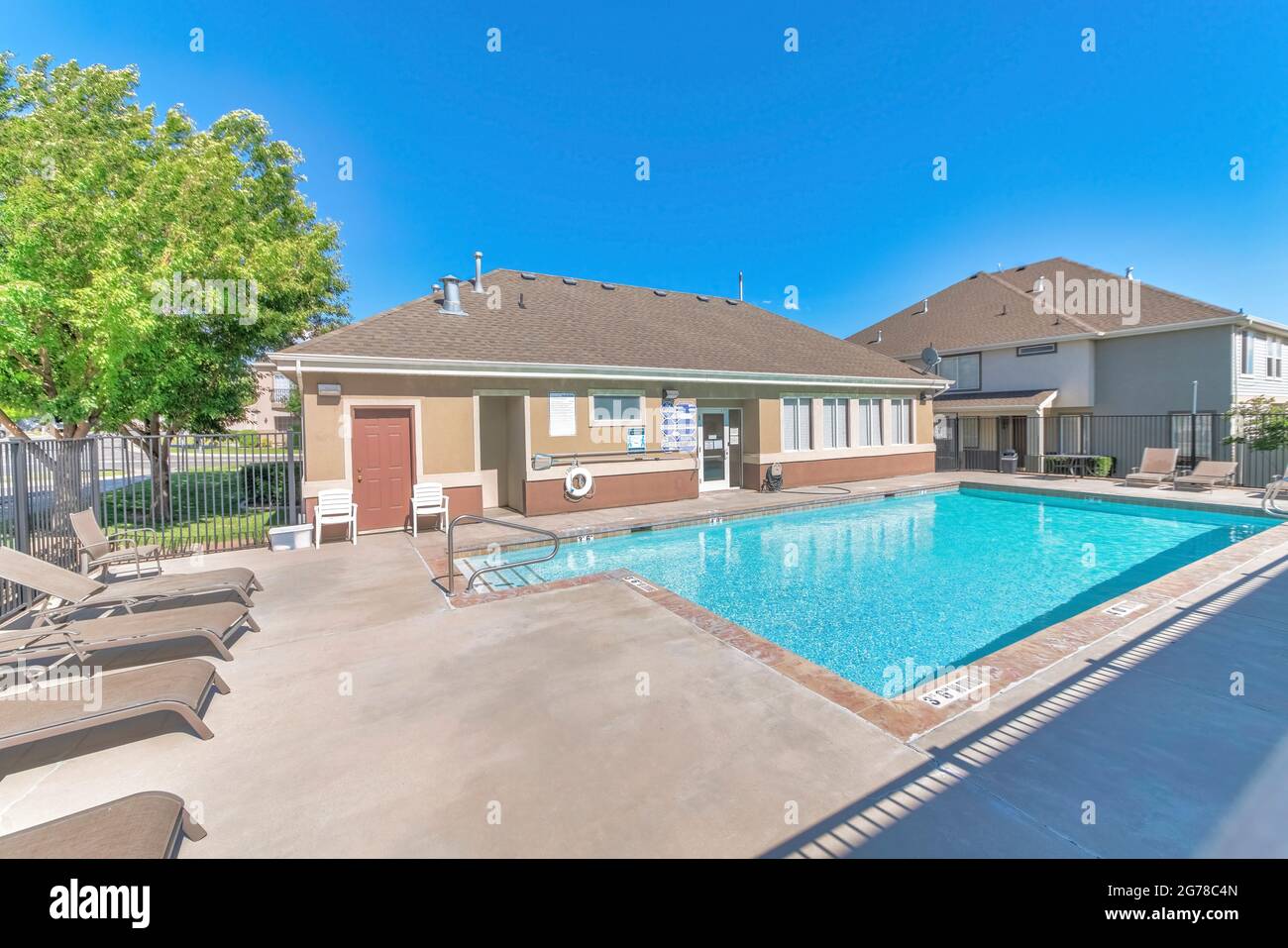 Public swimming pool with office building and relaxing outdoor lounge ...