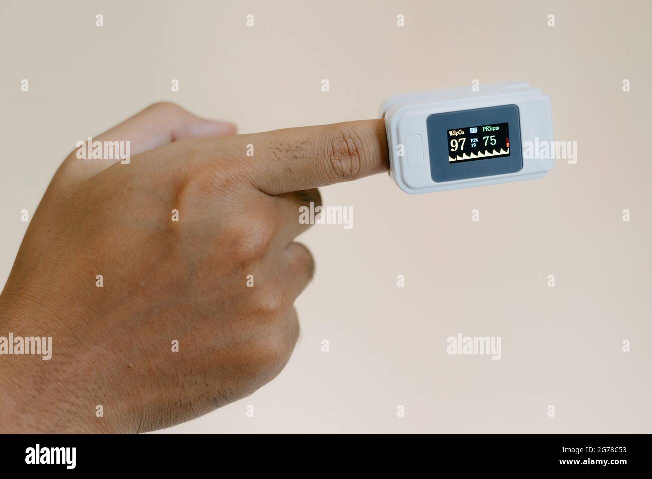 An index finger clamped with oximeter shows the oxygen saturation level ...