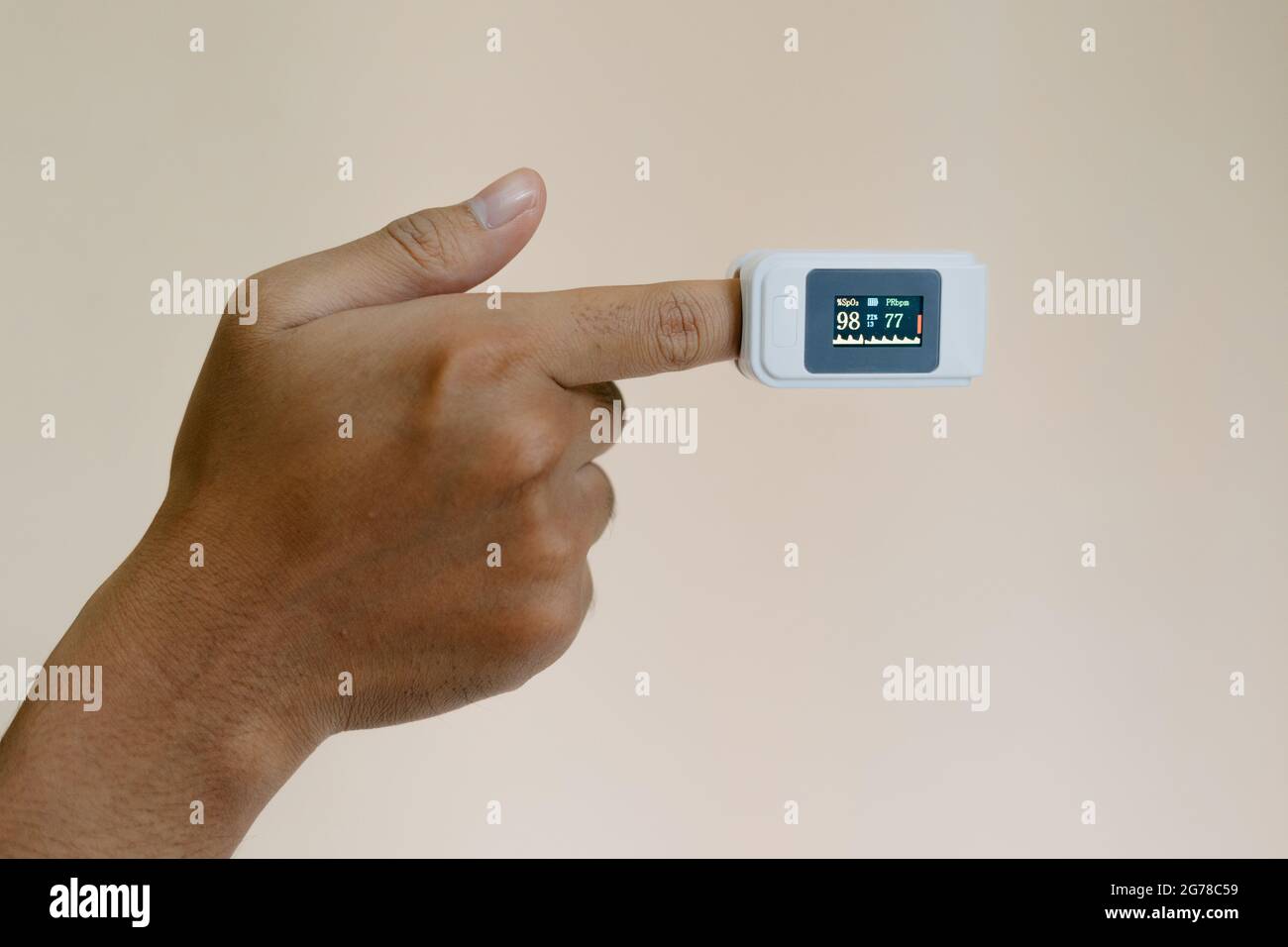 An index finger clamped with oximeter shows the oxygen saturation level ...